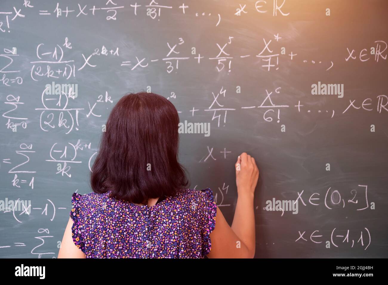 Teacher or student writing on blackboard during math lesson in school ...