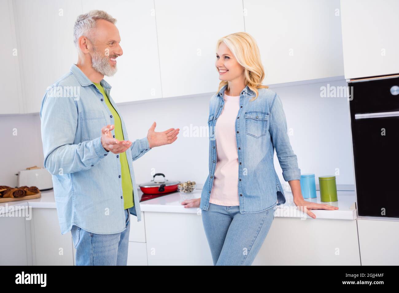 Photo of busy charming aged couple wear denim shirt smiling discussing ...