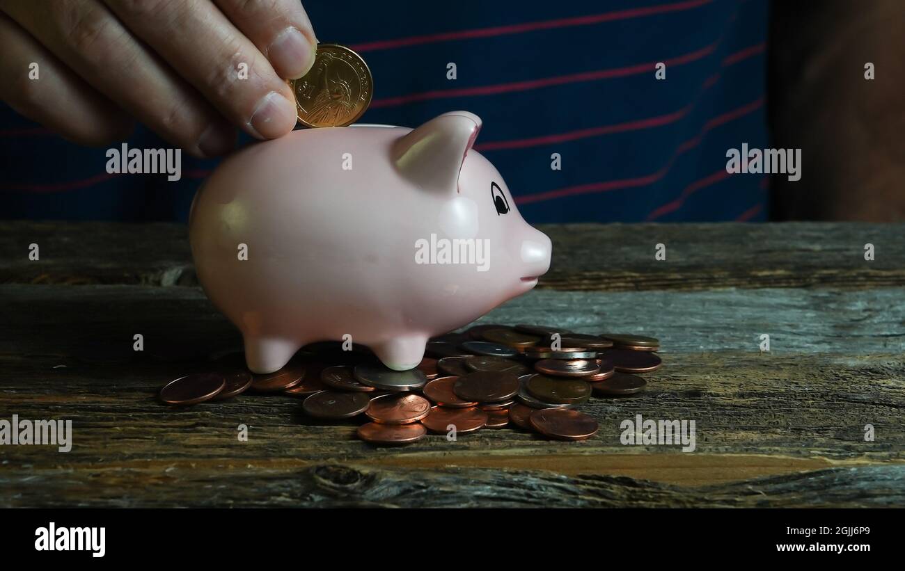 Adding money inside piggy bank hi-res stock photography and images - Alamy