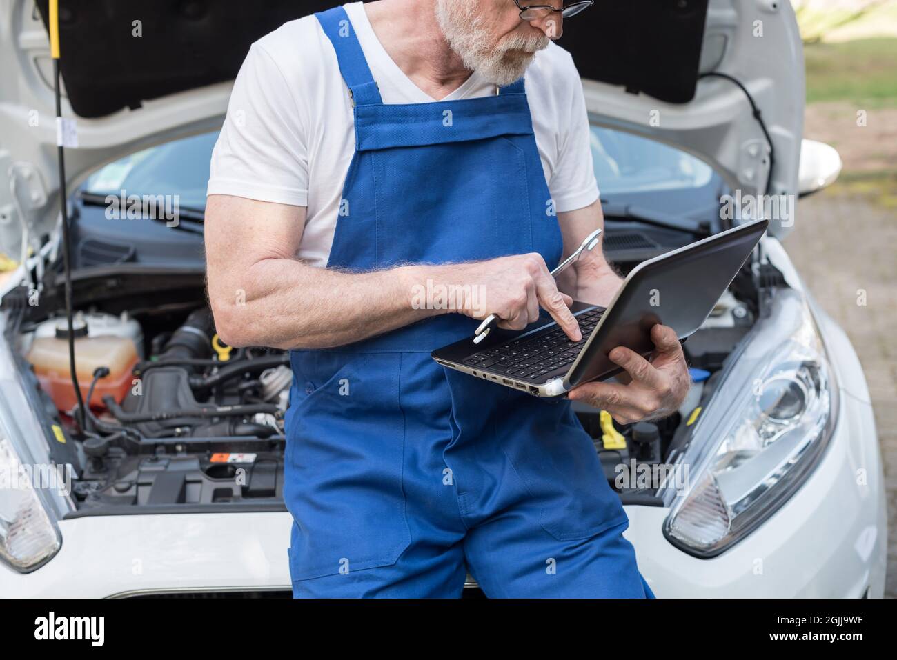 Car mechanic using laptop for checking car engine Stock Photo - Alamy