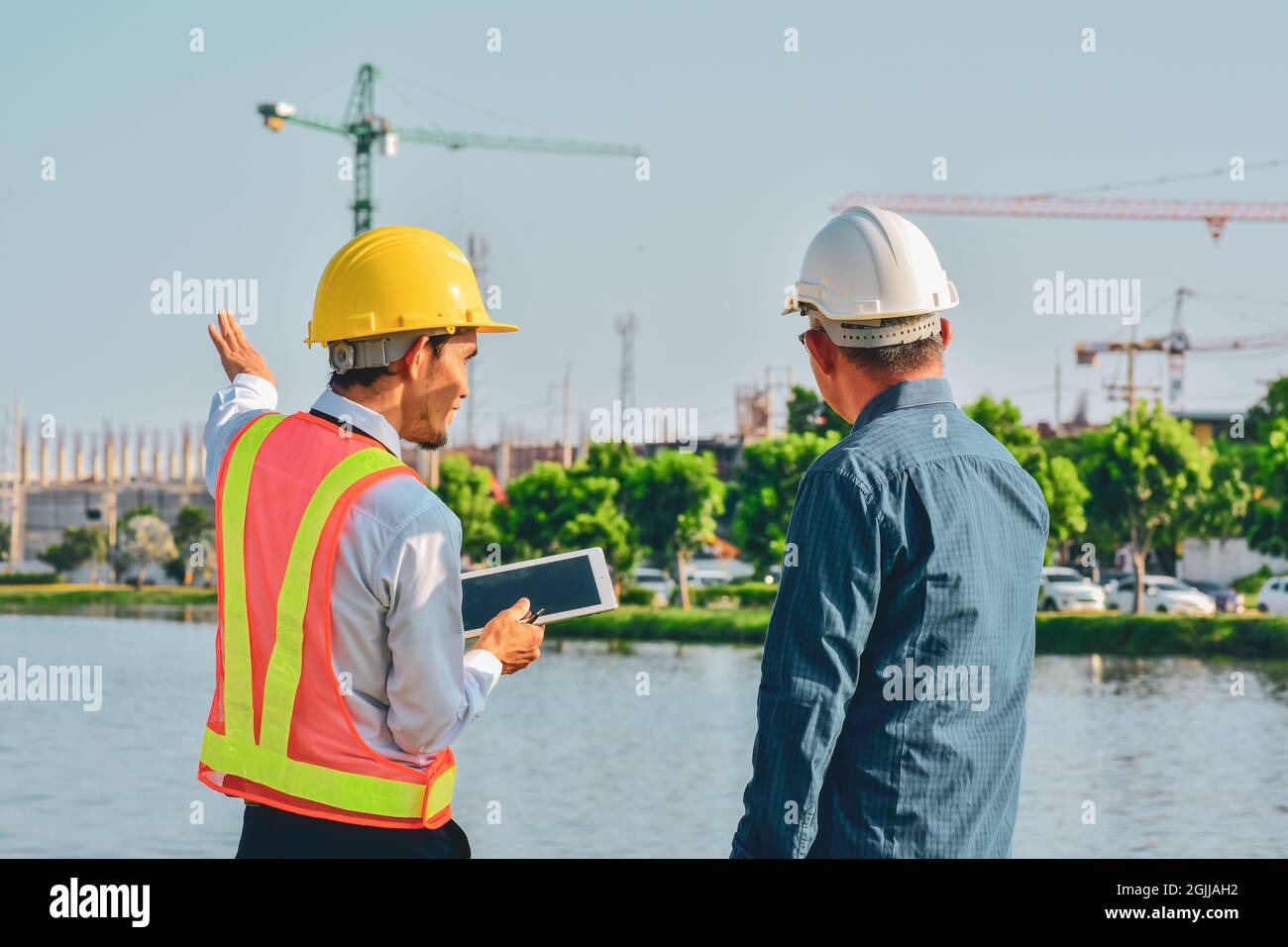 Two engineers construction plan talking hi-res stock photography and ...