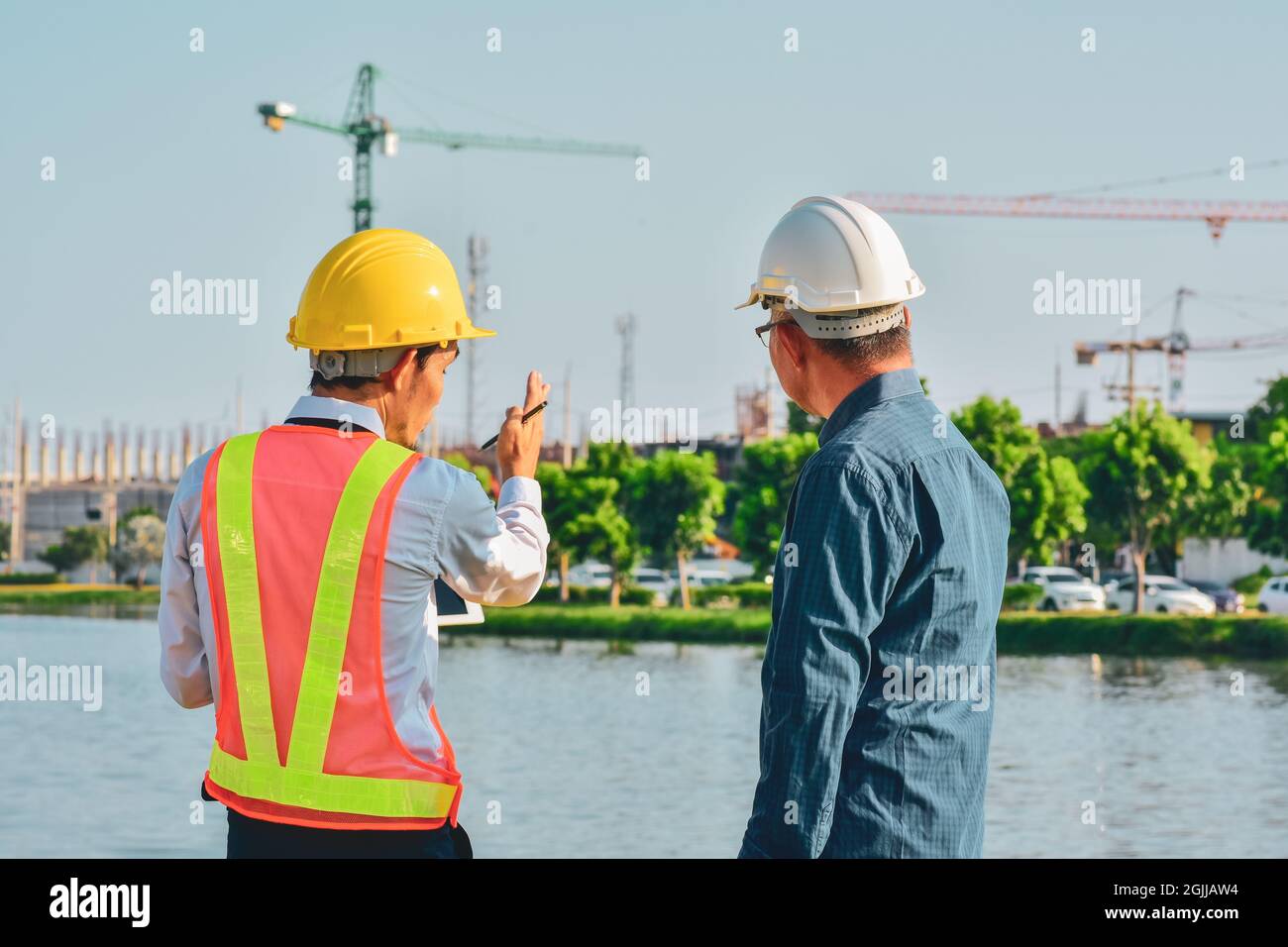 Two Engineer talking plan construction site project Stock Photo - Alamy