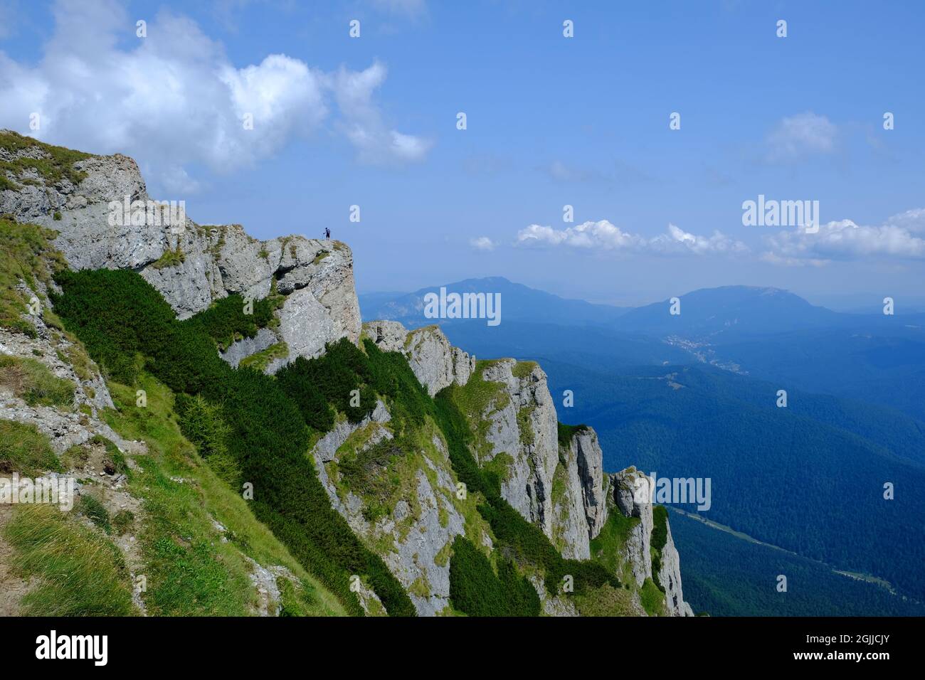 Hiking on the ridge of the amazing rocks of the Caraiman Peak, Bucegi ...