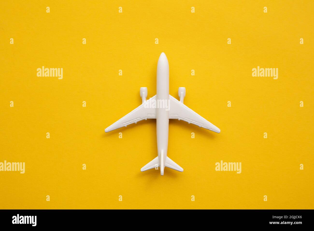 White passenger airplane on a summer yellow background. Travel and ...