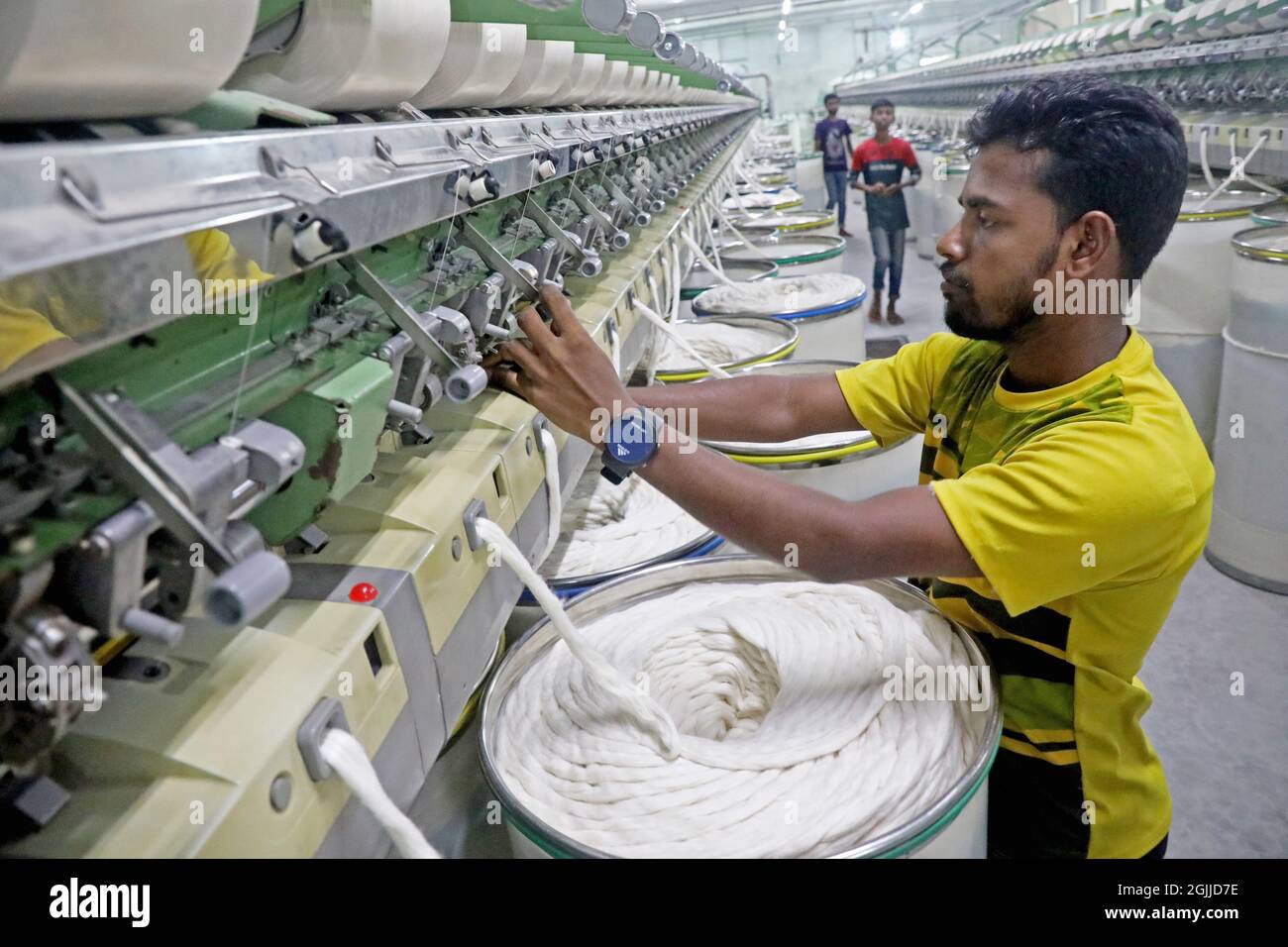 An employee during a process of yarns production before the manufacture ...