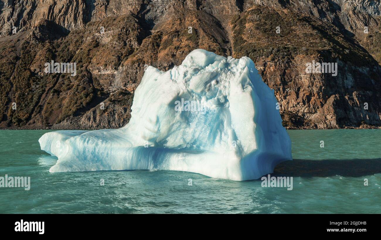 huge block of ice, called an iceberg, floating adrift through the water ...