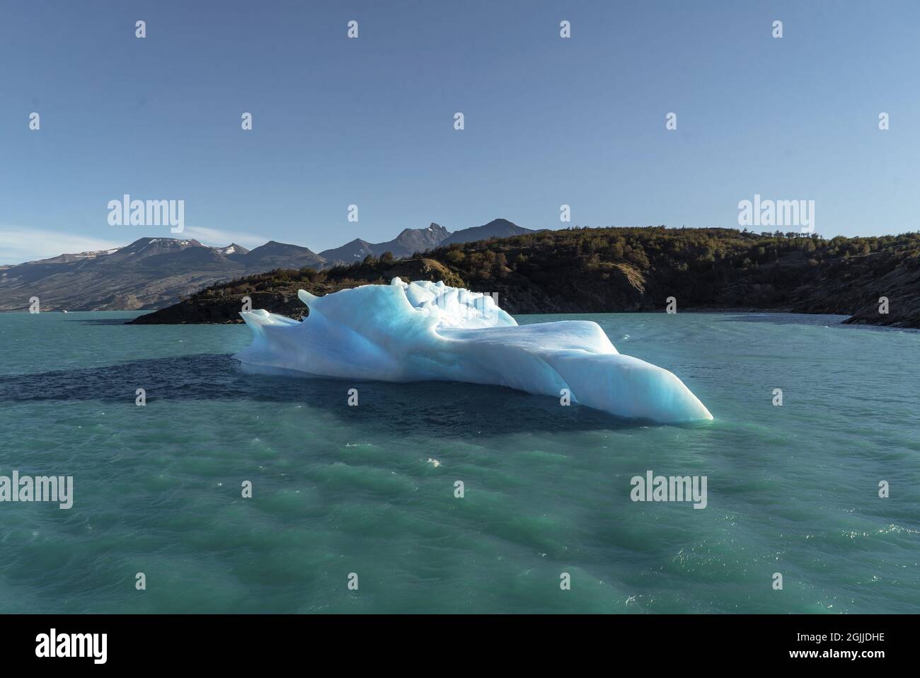 huge block of ice, called an iceberg, floating adrift through the water ...