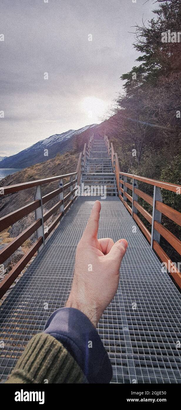 Vertical shot of a man's hand showing with his finger the front view of ...