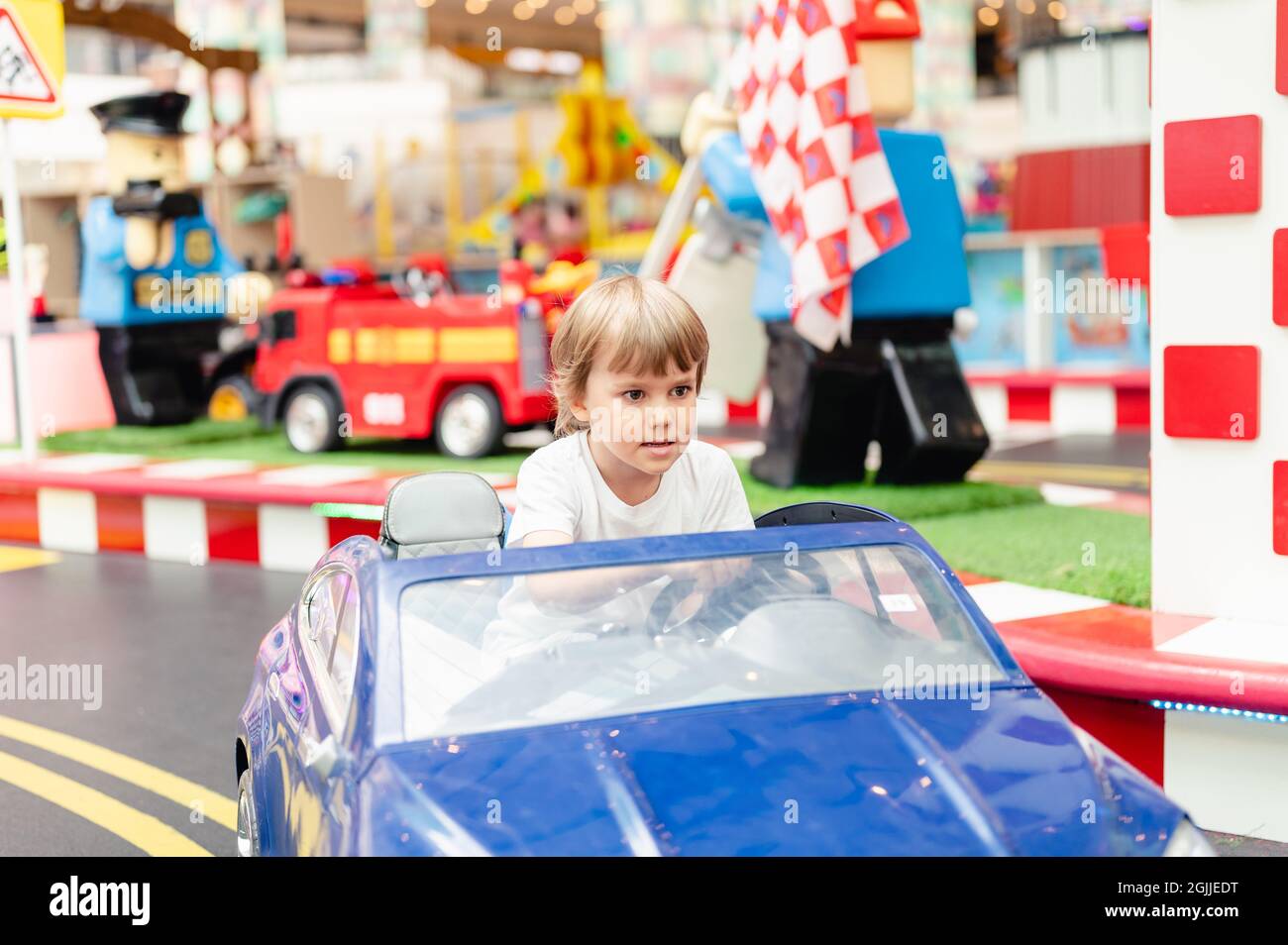 little happy four years old kid boy fun riding an small electric cars ...