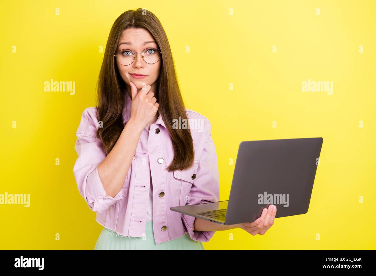 Portrait of attractive minded puzzled girl using laptop deciding ...