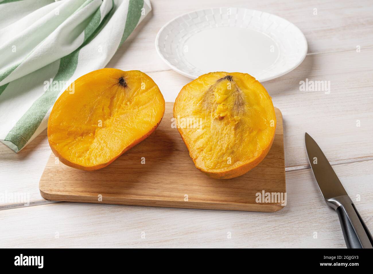 Cutting mango into half white hi-res stock photography and images - Alamy