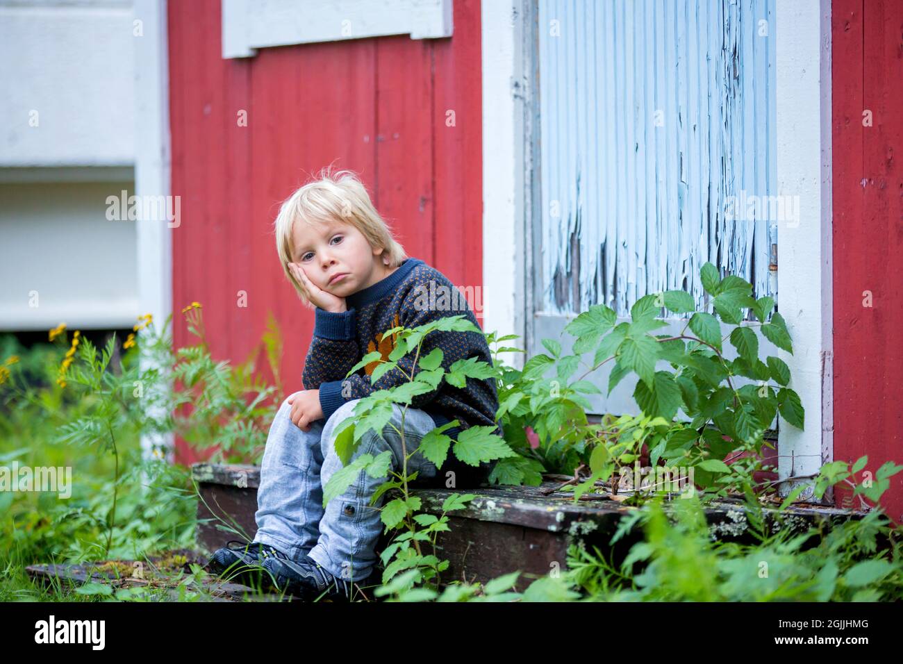 Sad little child, preschool boy, sitting on stairs in front of old ...