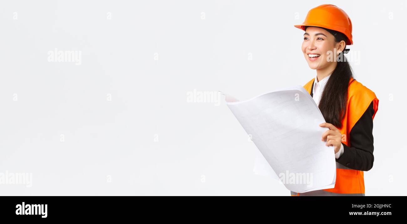Satisfied happy asian female chief engineer looking at results of ...