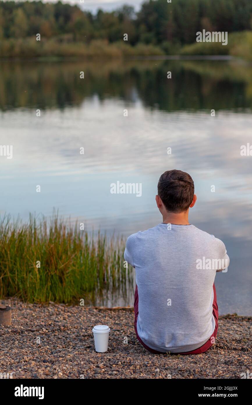 Man sitting on lake shore hi-res stock photography and images - Alamy