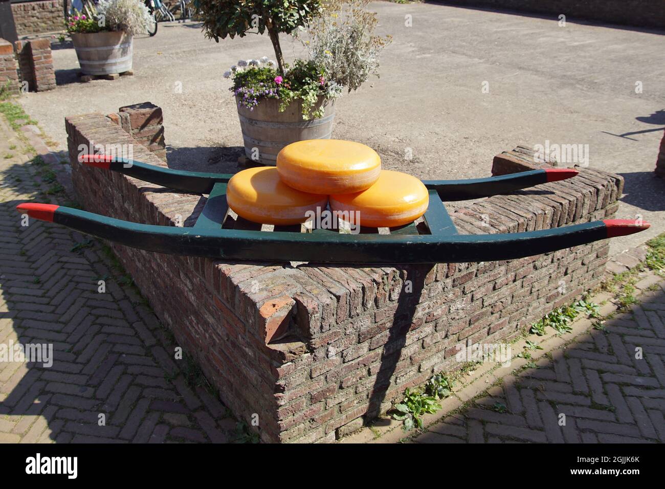 Dutch, small berrie with three round cheeses on it. On a brick wall and ...