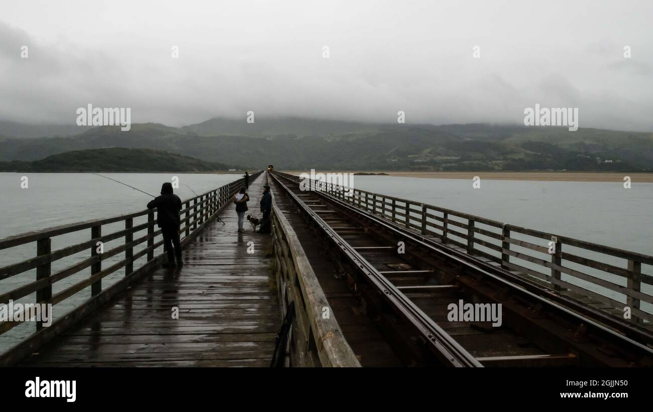 Fishing from Barmouth Bridge in the Rain Stock Photo - Alamy