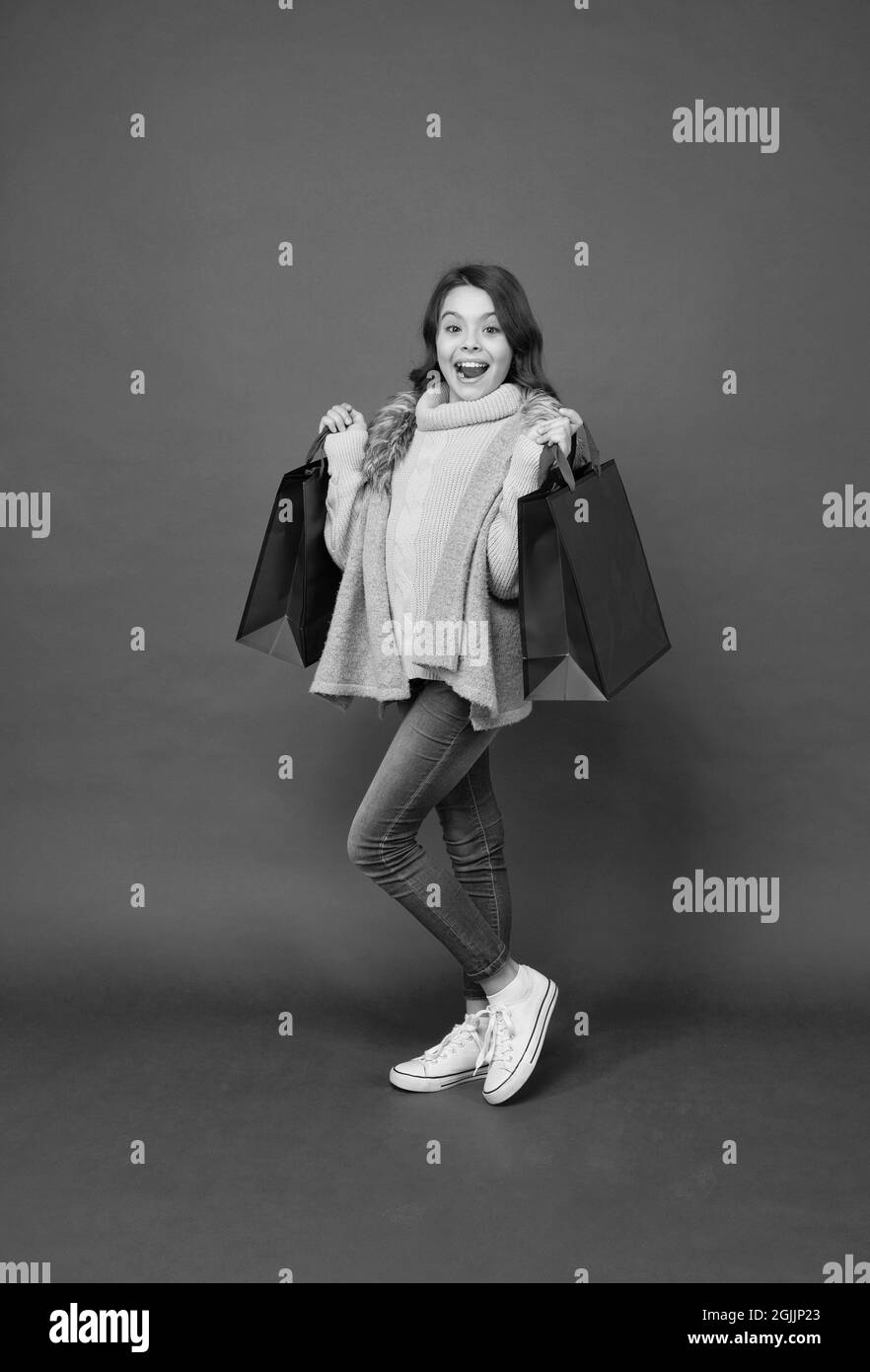 Happy small shopaholic with fashion look carry shopping bags red ...