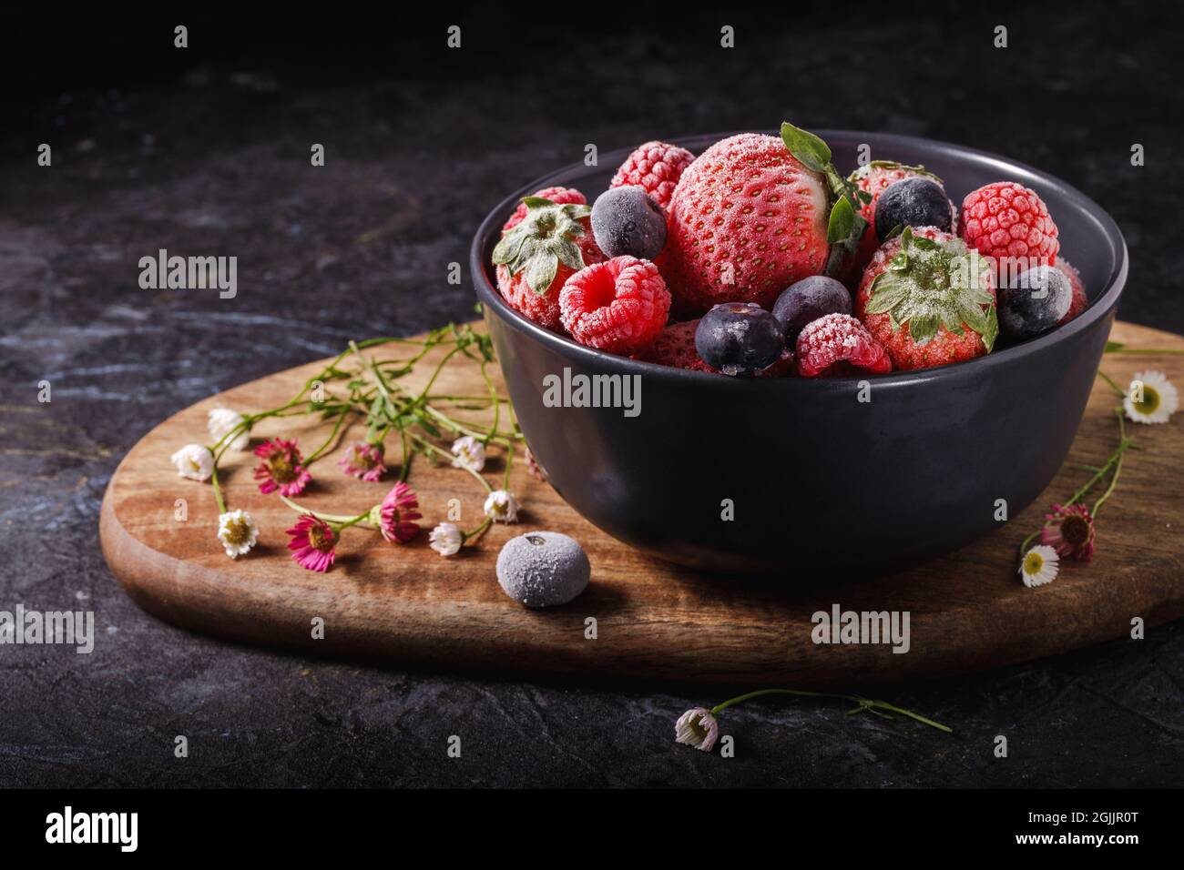 Black bowl of frozen red fruits Stock Photo - Alamy