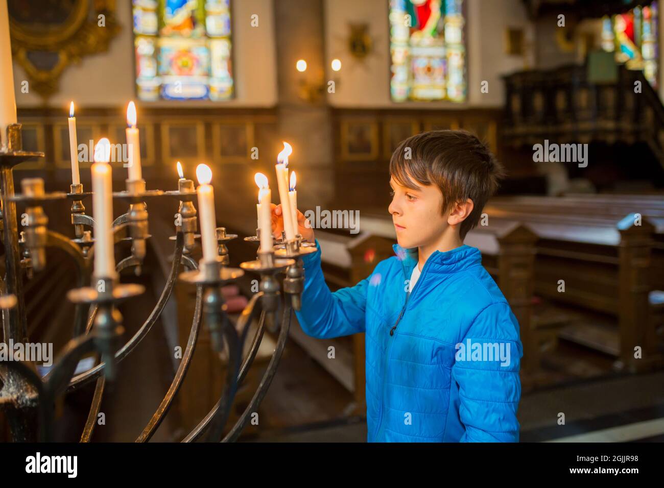 Little child, boy, praying in church, cathedrale in Stockholm, Sweden ...