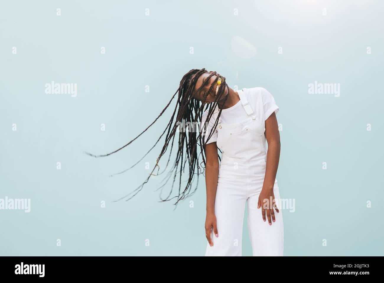 Young happy woman in white casuals standing outdoors while her face ...