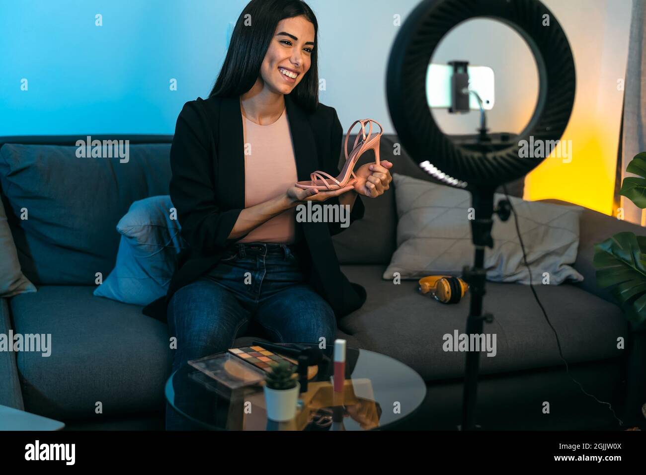 Female influencer vlogging online with smartphone cam and ring led from ...