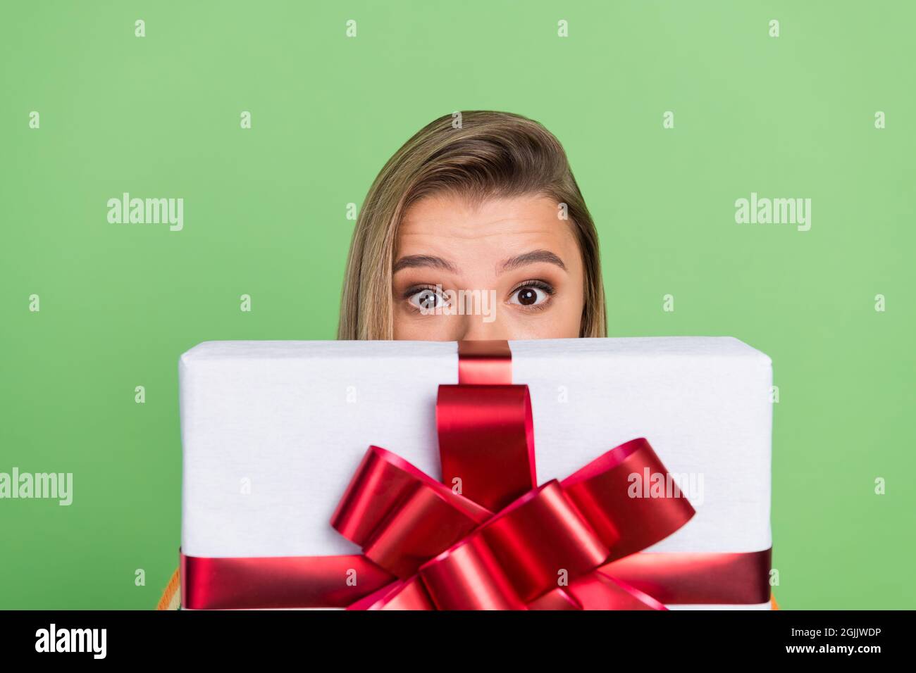 Photo portrait girl hiding face behind big present box at party staring ...