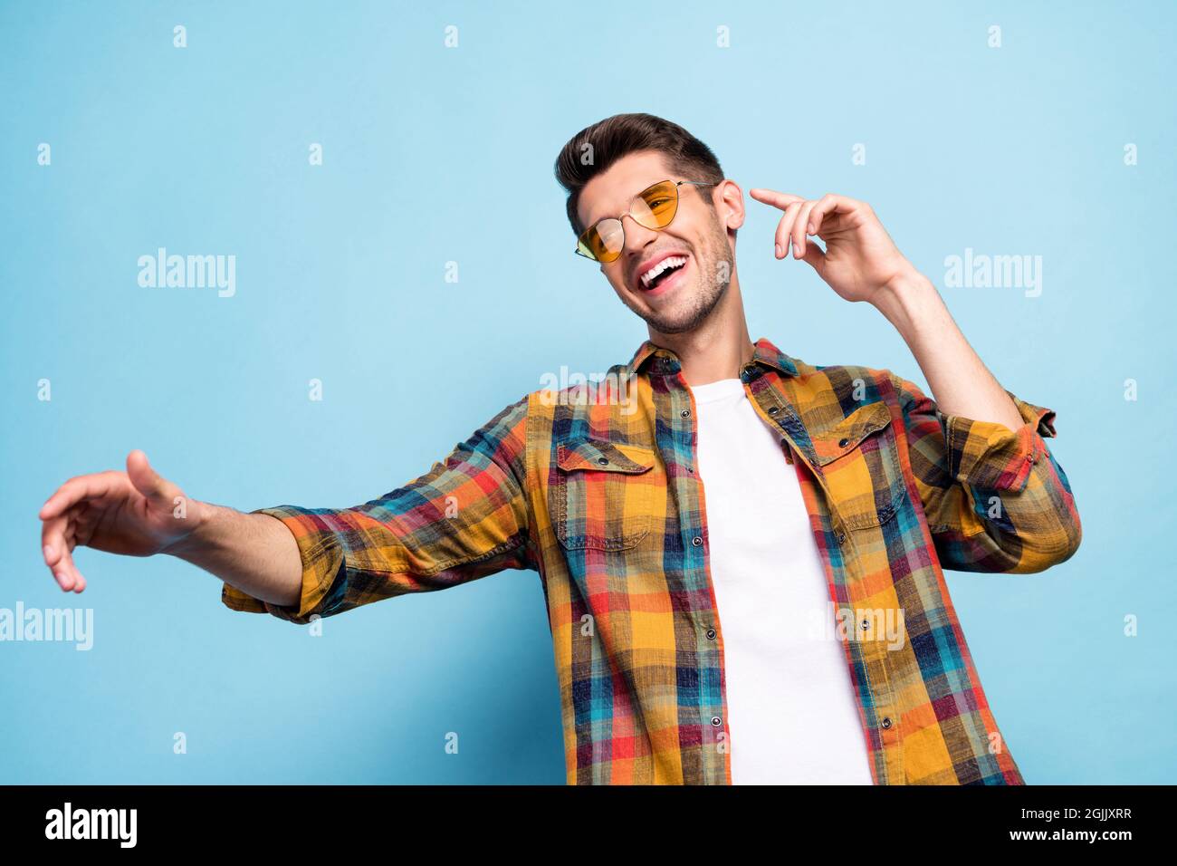 Portrait of attractive cheerful carefree guy dancing having fun resting ...