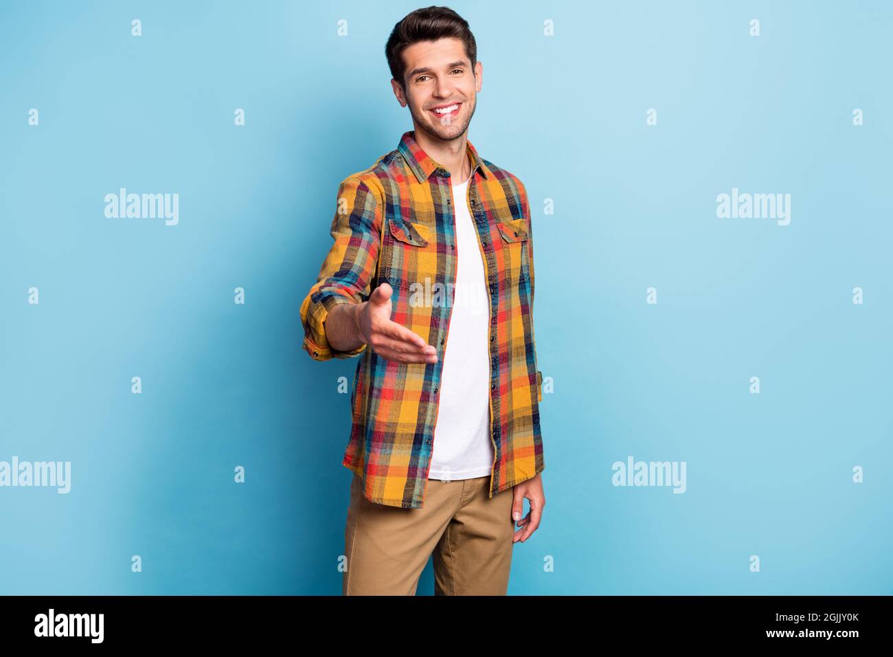 Portrait of attractive cheerful guy giving you hand welcoming new ...