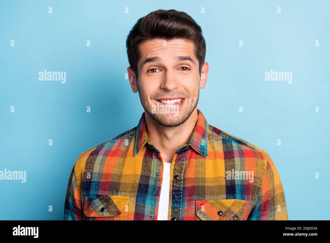 Portrait of attractive cheerful brunette guy wearing checked shirt ...