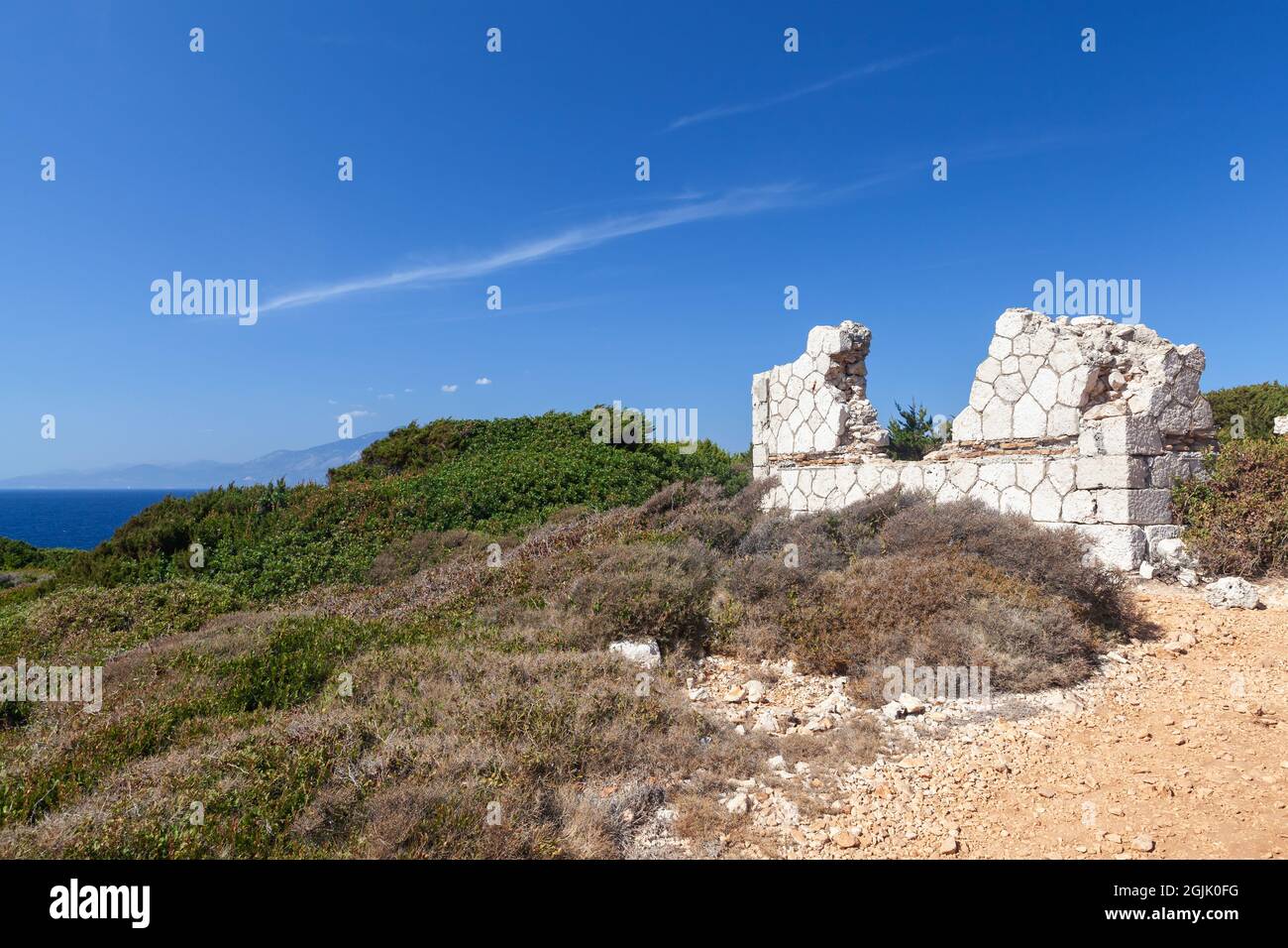 Rural summer landscape with ruins of an ancient white stone house on a ...