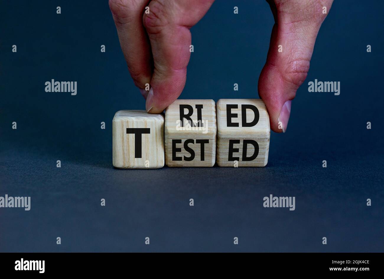 Tried and tested symbol. Businessman turns wooden cubes and changes the ...