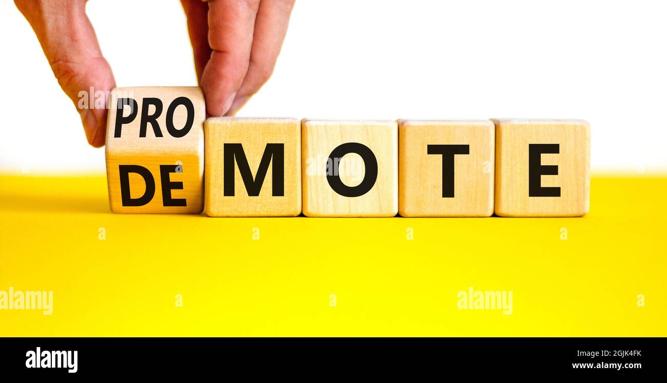Promote or demote symbol. Businessman turns a cube and changes the word ...