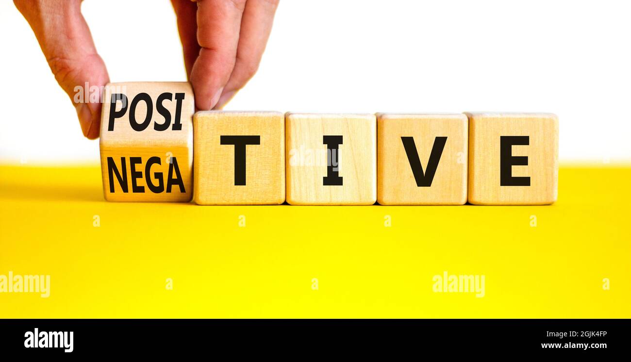 Positive or negative symbol. Businessman turns a wooden cube, changes ...