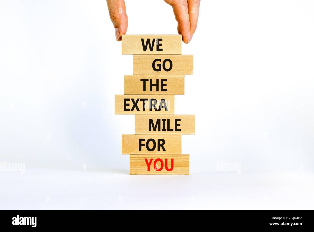 Go the extra mile symbol. Wooden blocks with words 'We go the extra ...