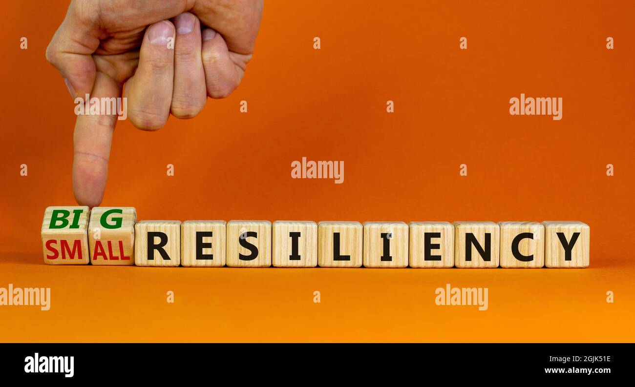 Big or small resiliency symbol. Businessman turns wooden cubes, changes ...