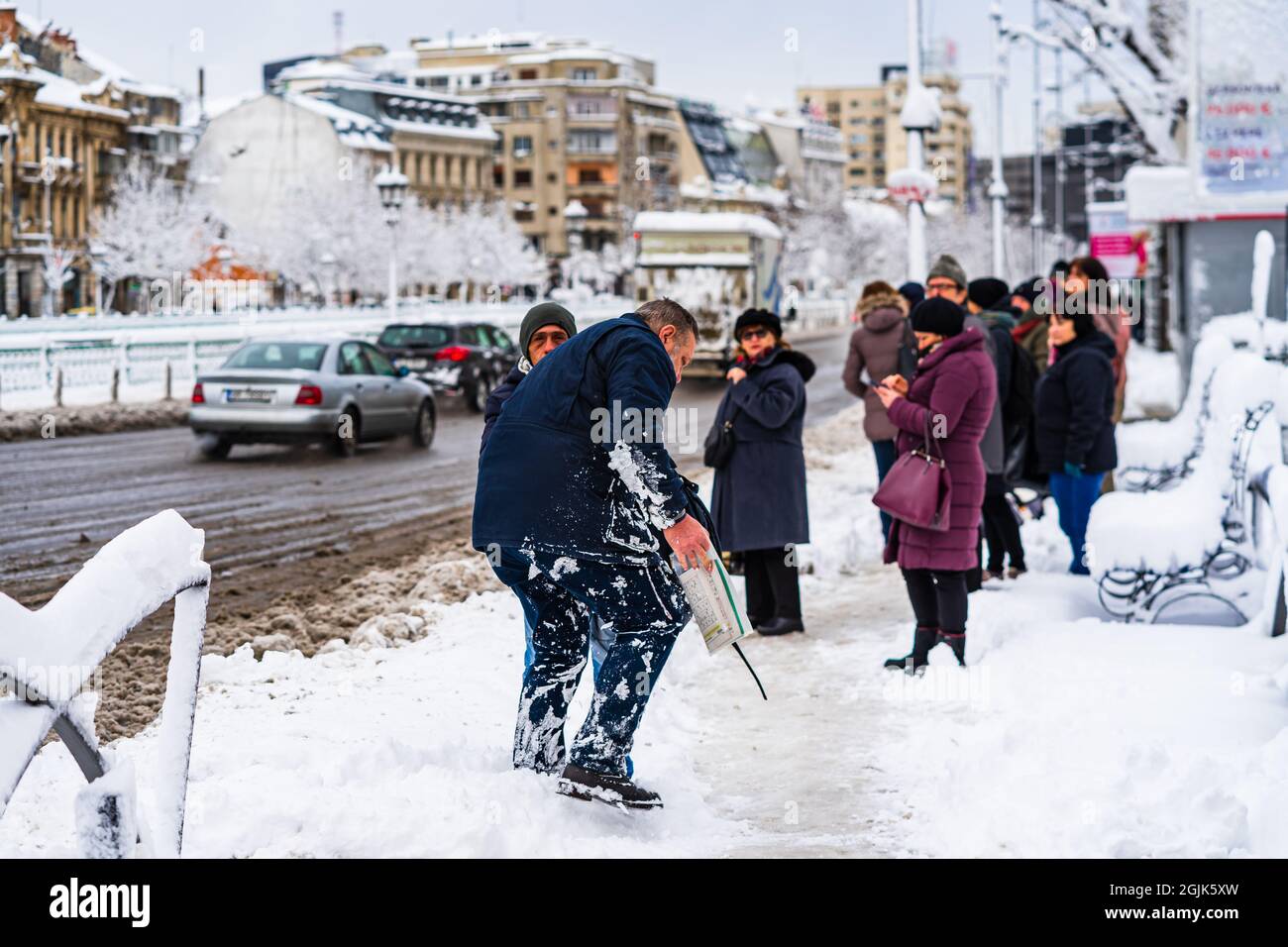 People wearing winter coats on snowy street in Bucharest, Romania, 2021 ...