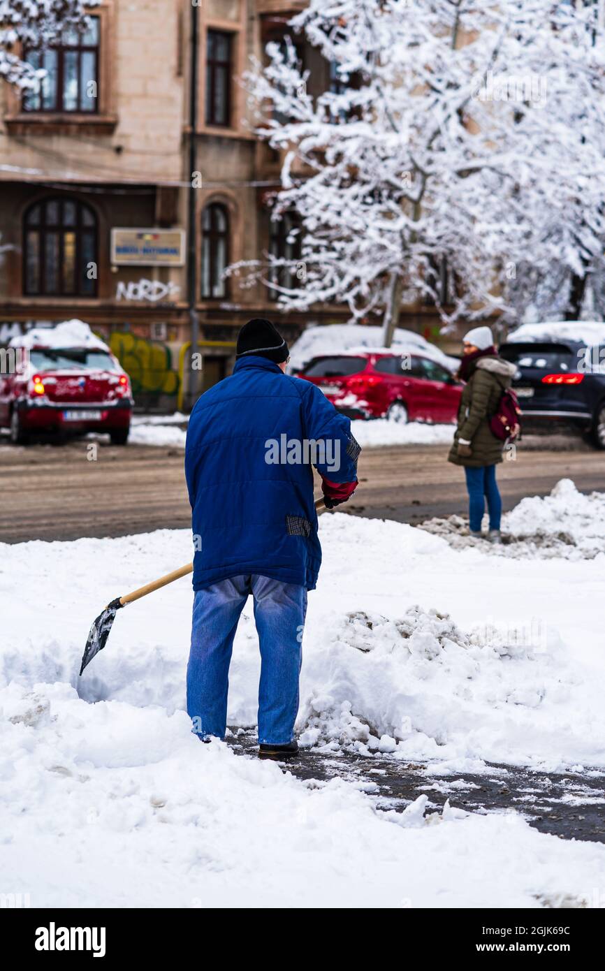 Snow removal, worker cleaning the snowy road in Bucharest, Romania ...