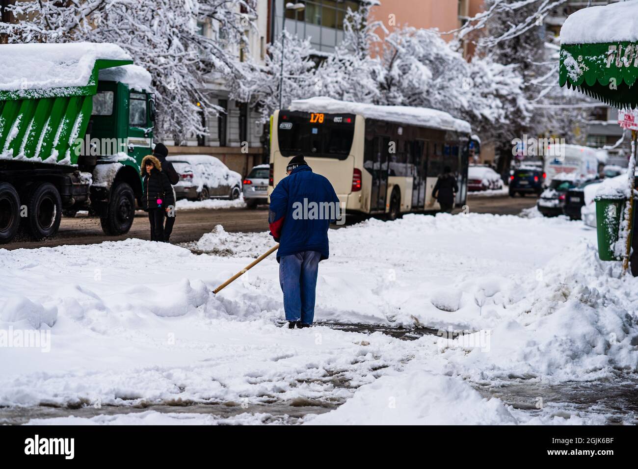 Snow removal, worker cleaning the snowy road in Bucharest, Romania ...