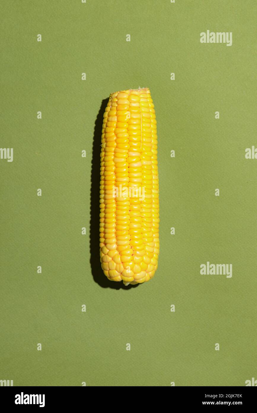 Top view of one corn on green background Stock Photo - Alamy