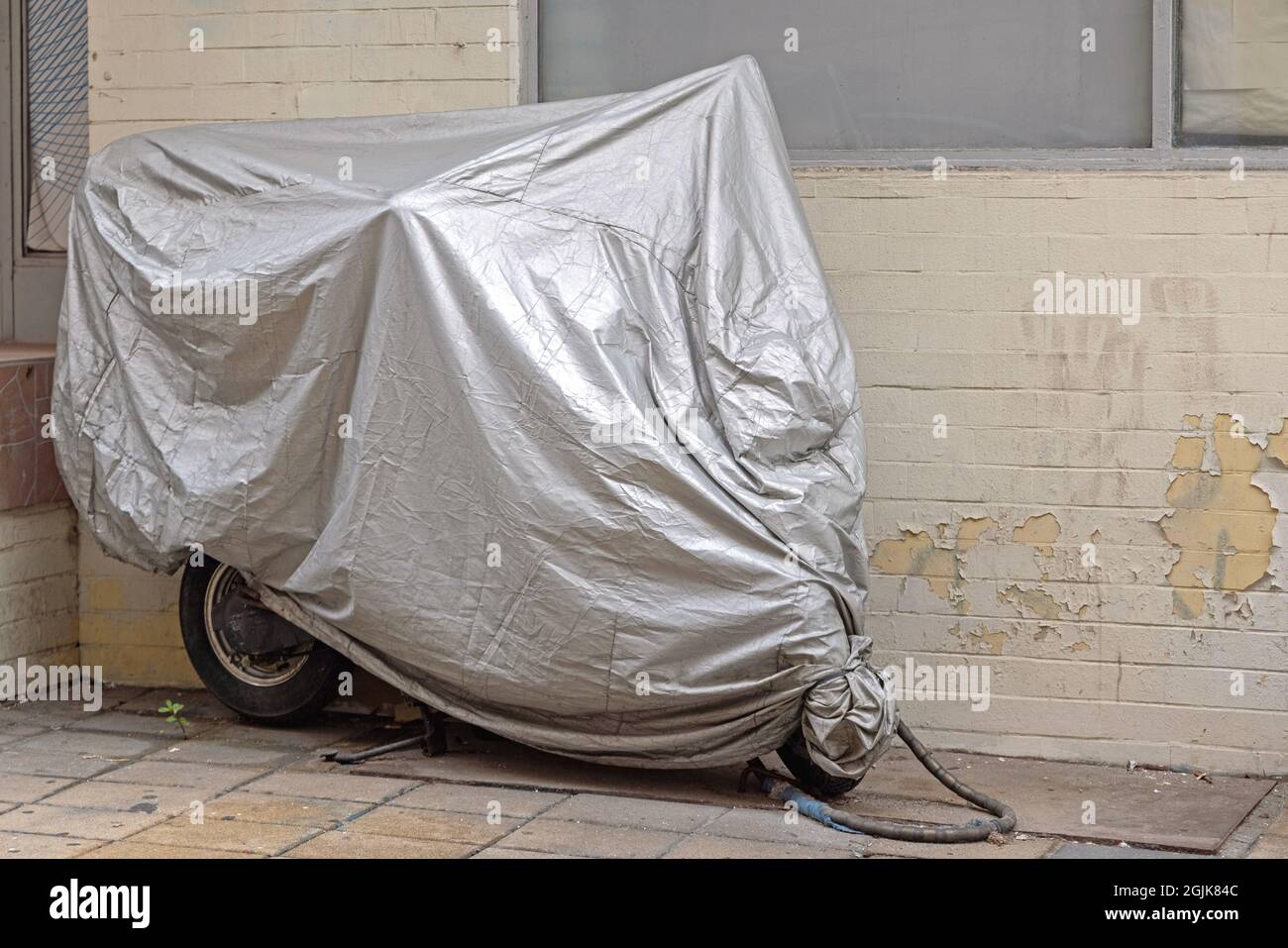 Motorcycle Storage in Corner Under Silver Tarp Rain Cover Stock Photo ...