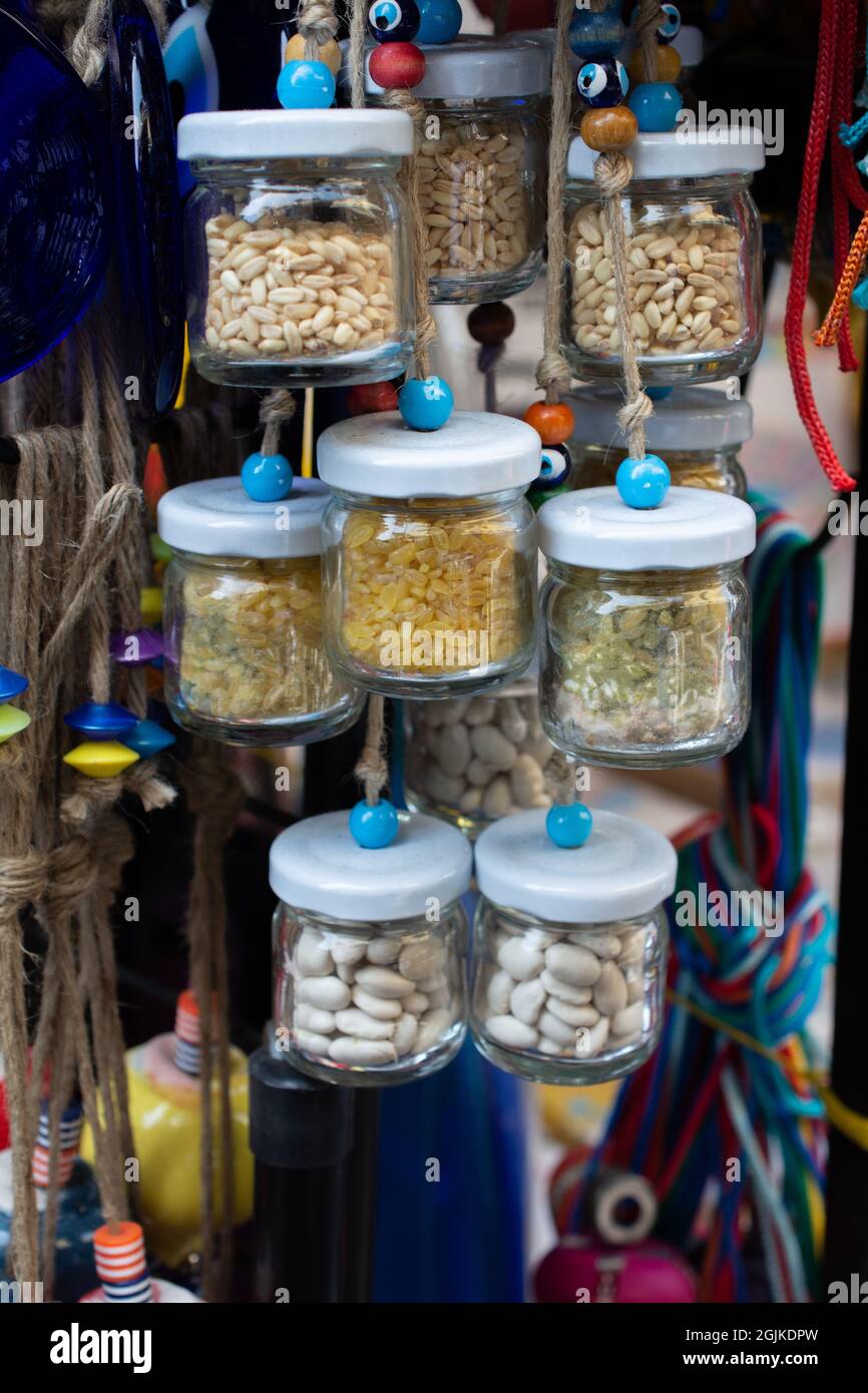 Vertical shot of small transparent jars with different grains hung on a ...