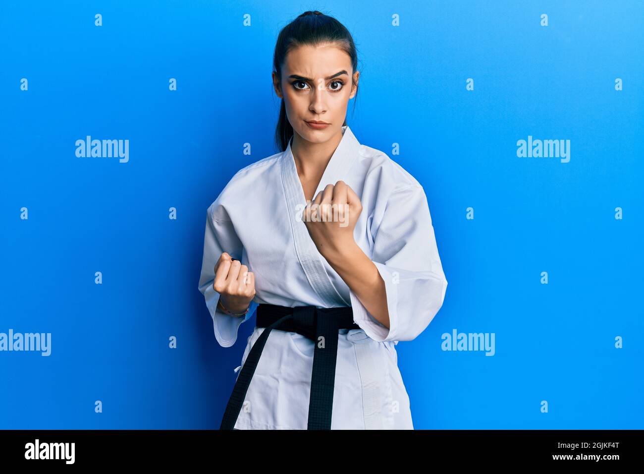 Beautiful brunette young woman wearing karate fighter uniform with ...