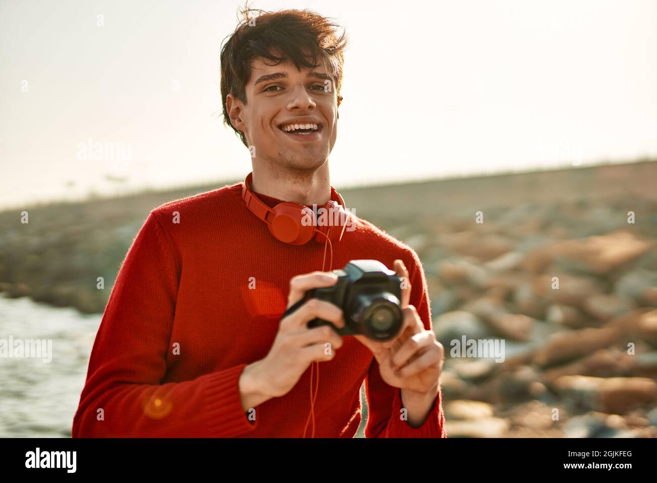 Young hispanic man smiling happy using reflex camera at the beach Stock ...