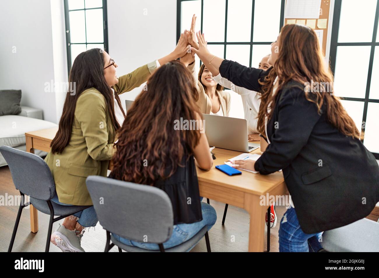 Group of businesswomen smiling happy celebrating high five at the ...