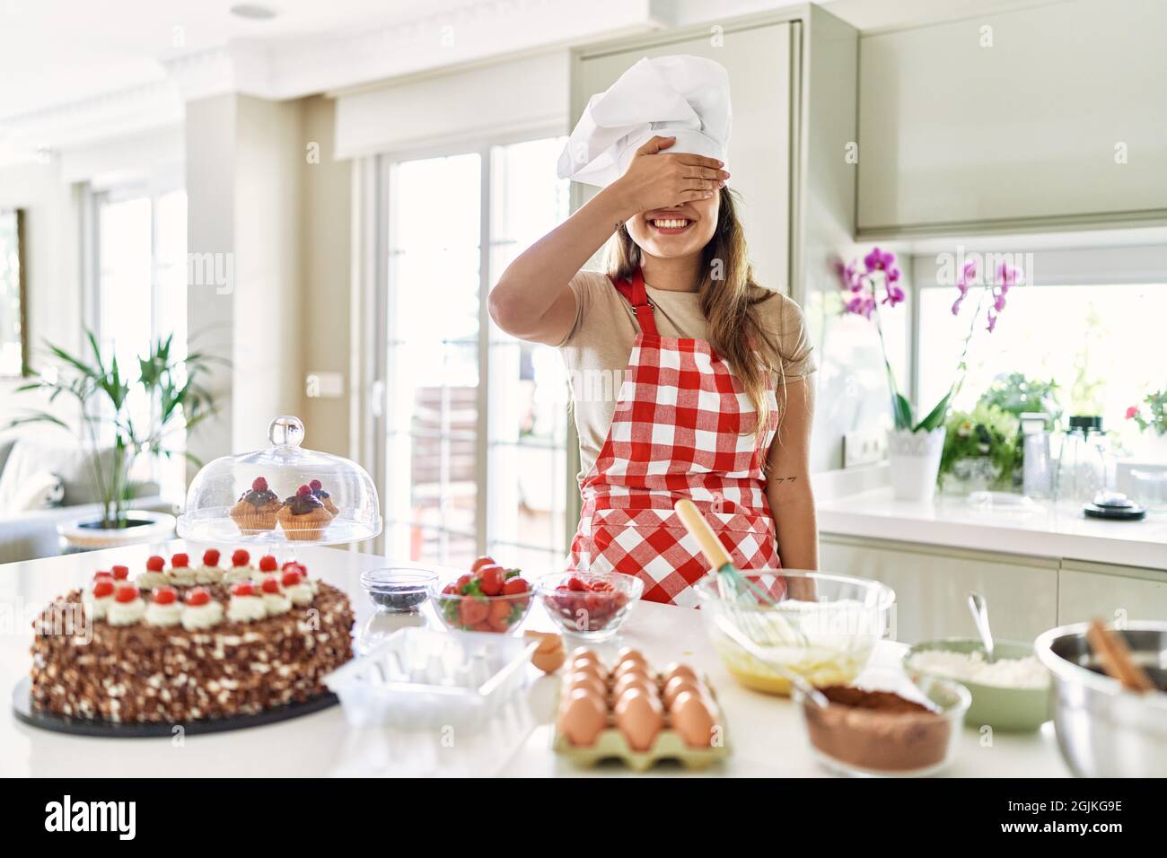 Beautiful young brunette pastry chef woman cooking pastries at the ...