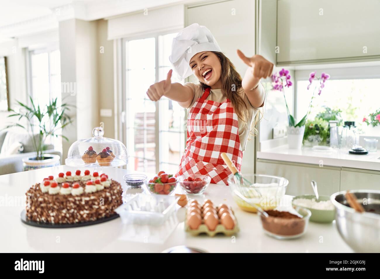 Beautiful young brunette pastry chef woman cooking pastries at the ...