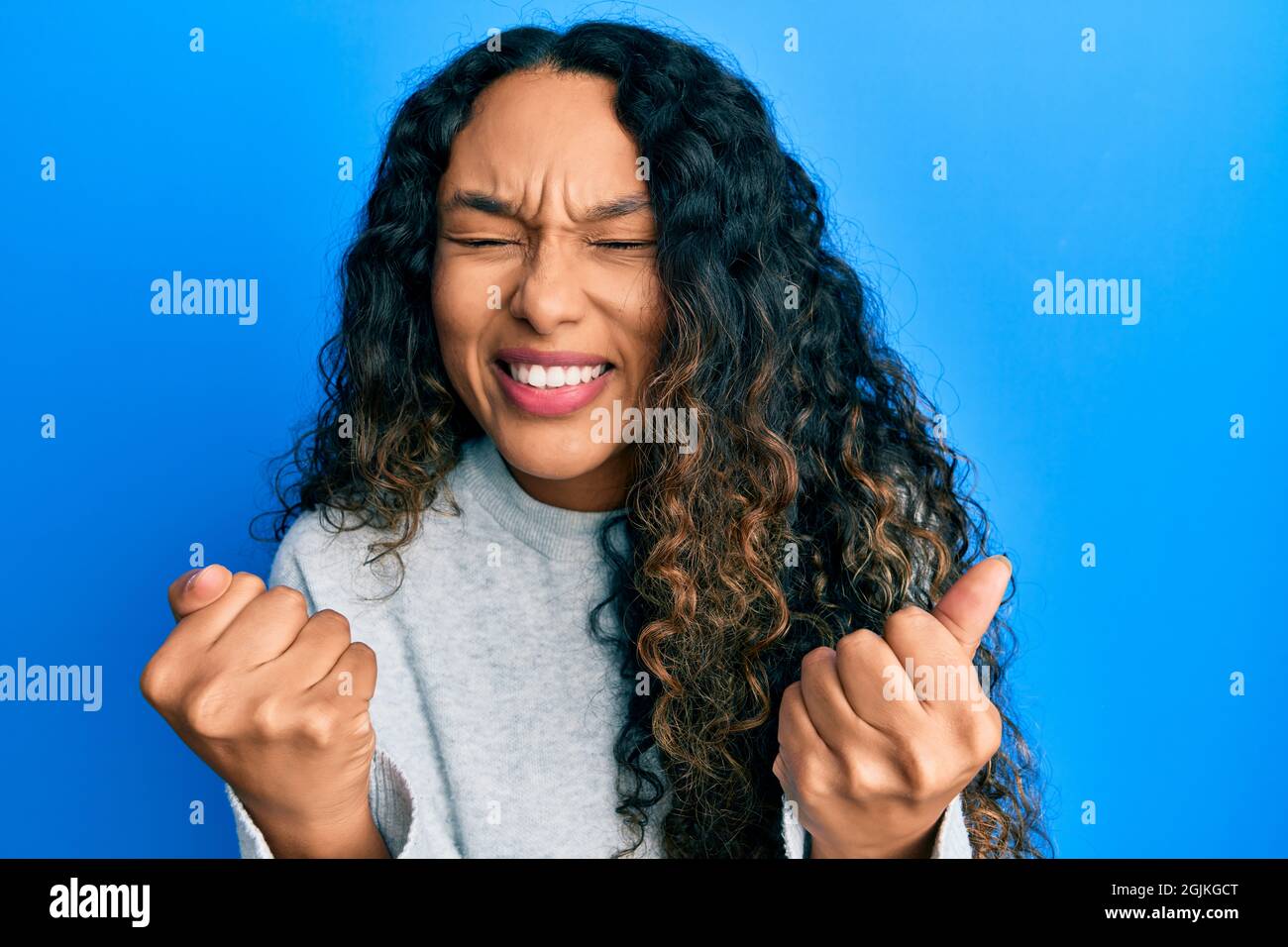 Young latin woman wearing casual clothes very happy and excited doing ...