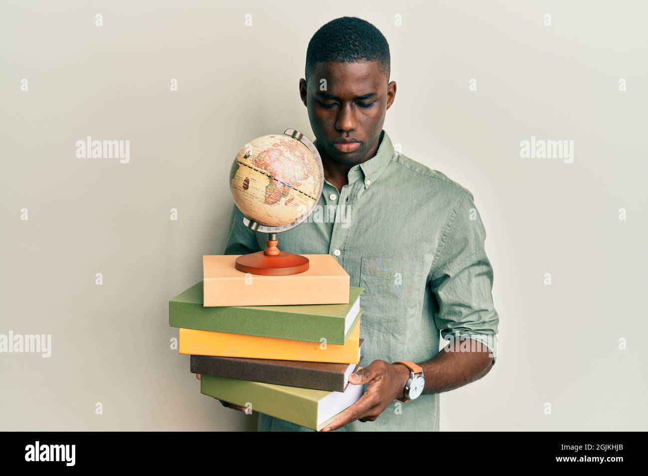 Young african american man holding vintage world ball and books ...