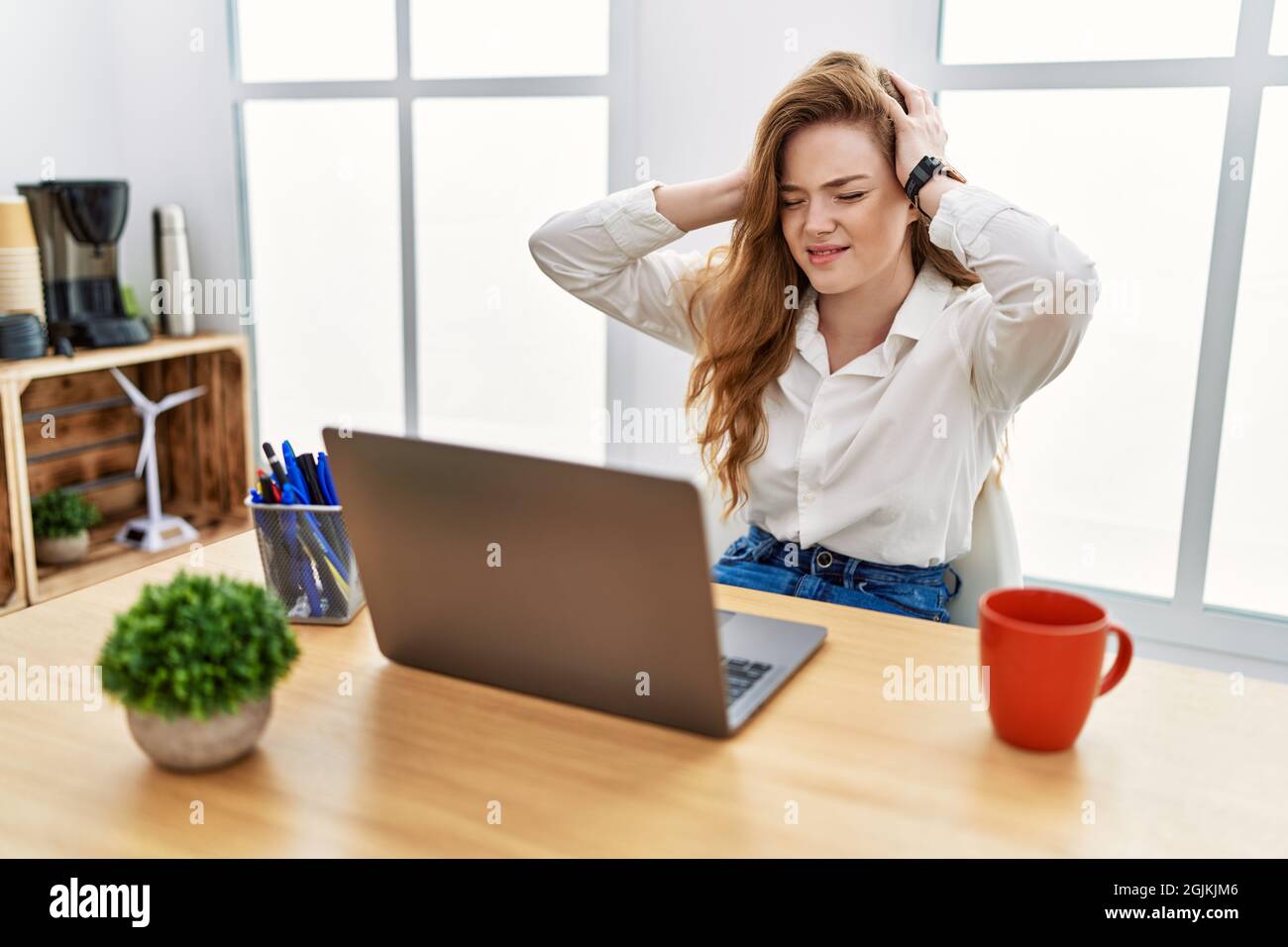 Young caucasian woman working at the office using computer laptop ...