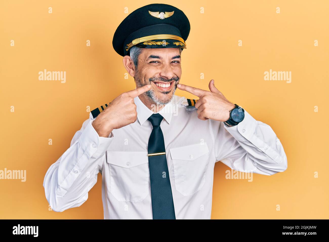 Handsome middle age man with grey hair wearing airplane pilot uniform ...